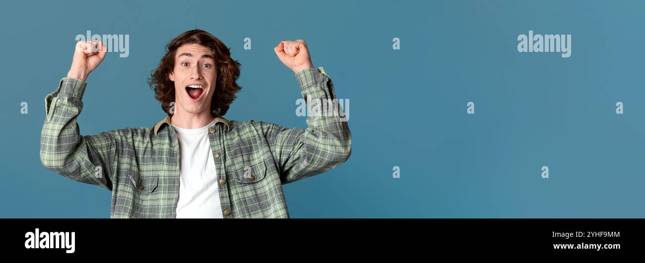 Success and celebration. Triumphant young guy showing victory gesture ...