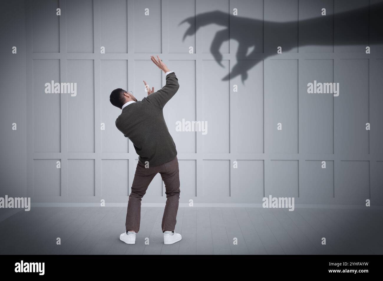 Man scared by monstrous hand reaching for him. Creepy shadow on light ...