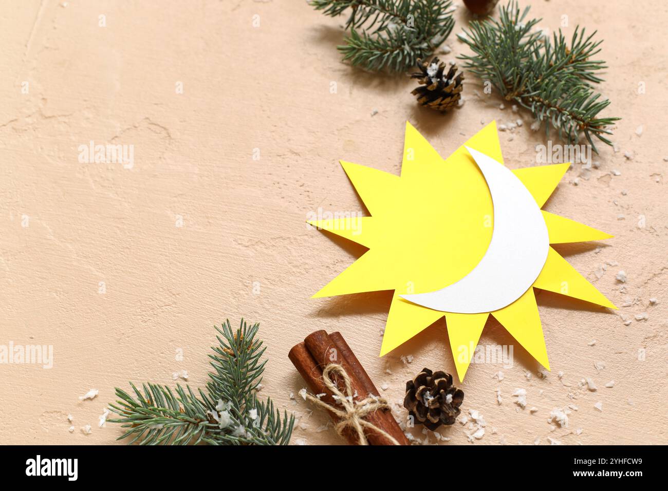 Paper sun with crescent, fir branches, cones and cinnamon on beige ...