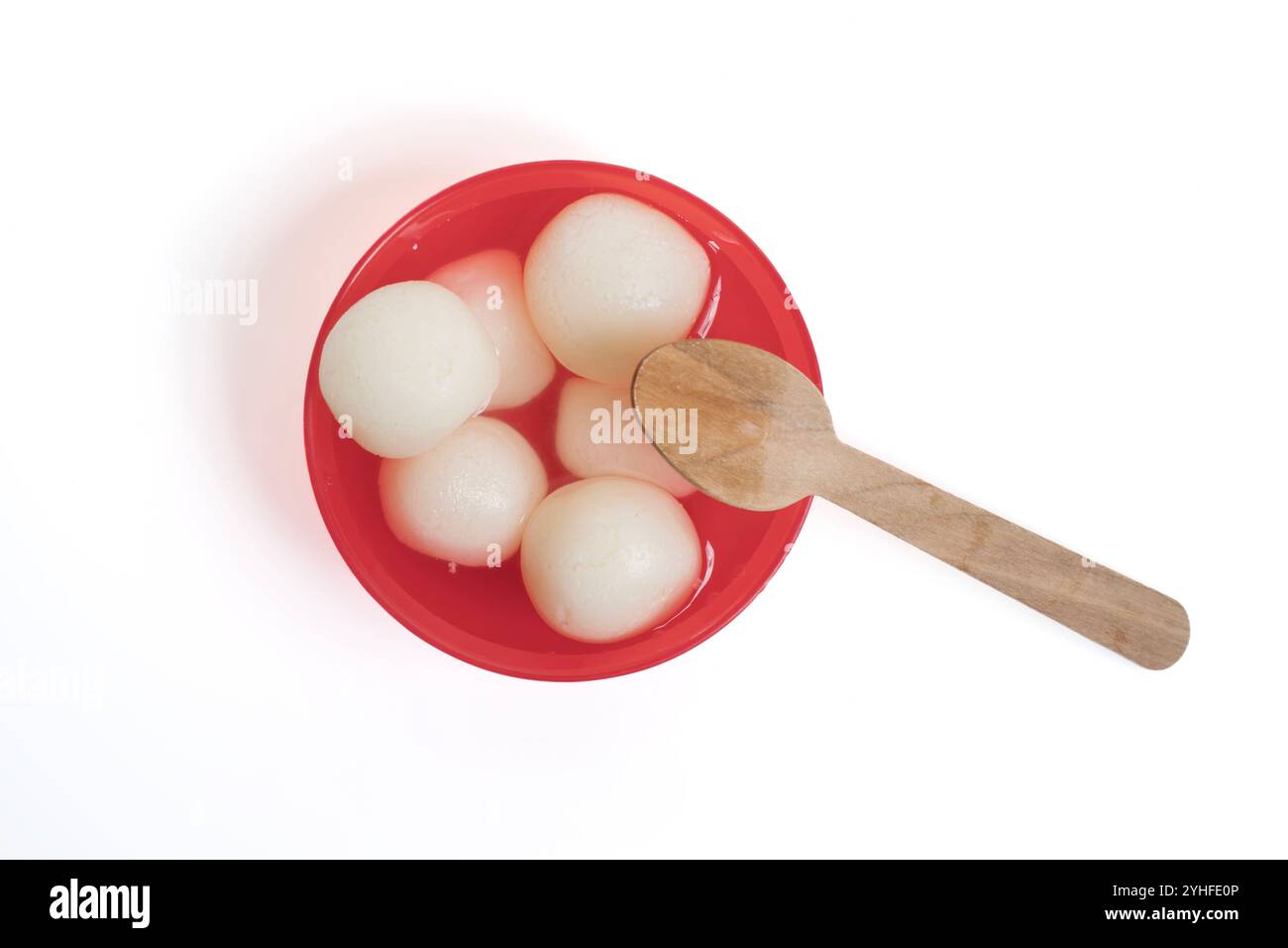 Traditional Indian sweet Rasgulla served in a red bowl with a wooden ...