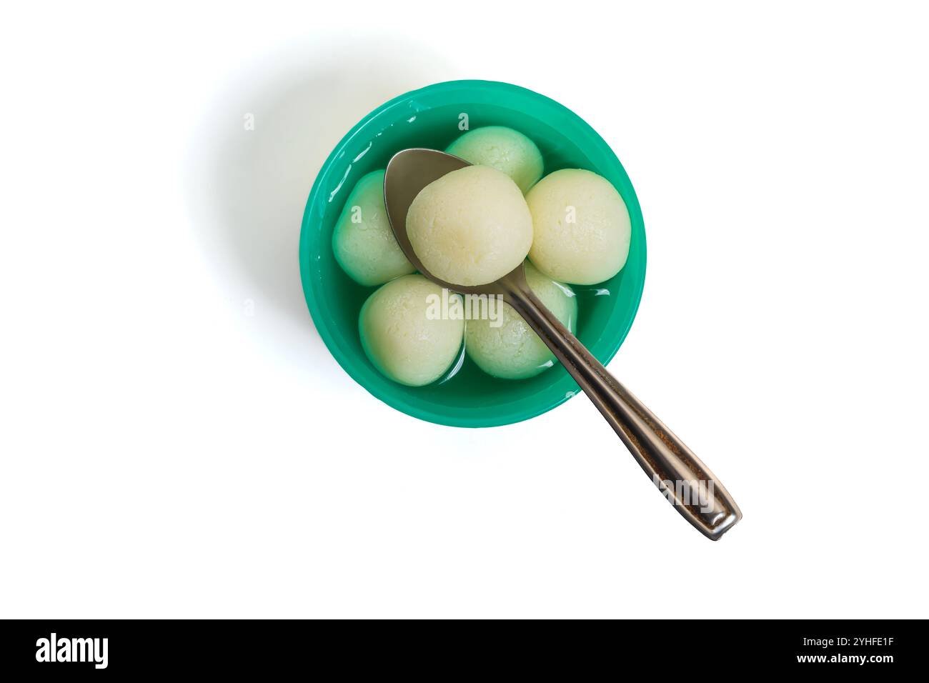 Traditional Indian rasgulla dessert in a green bowl with spoon on a ...