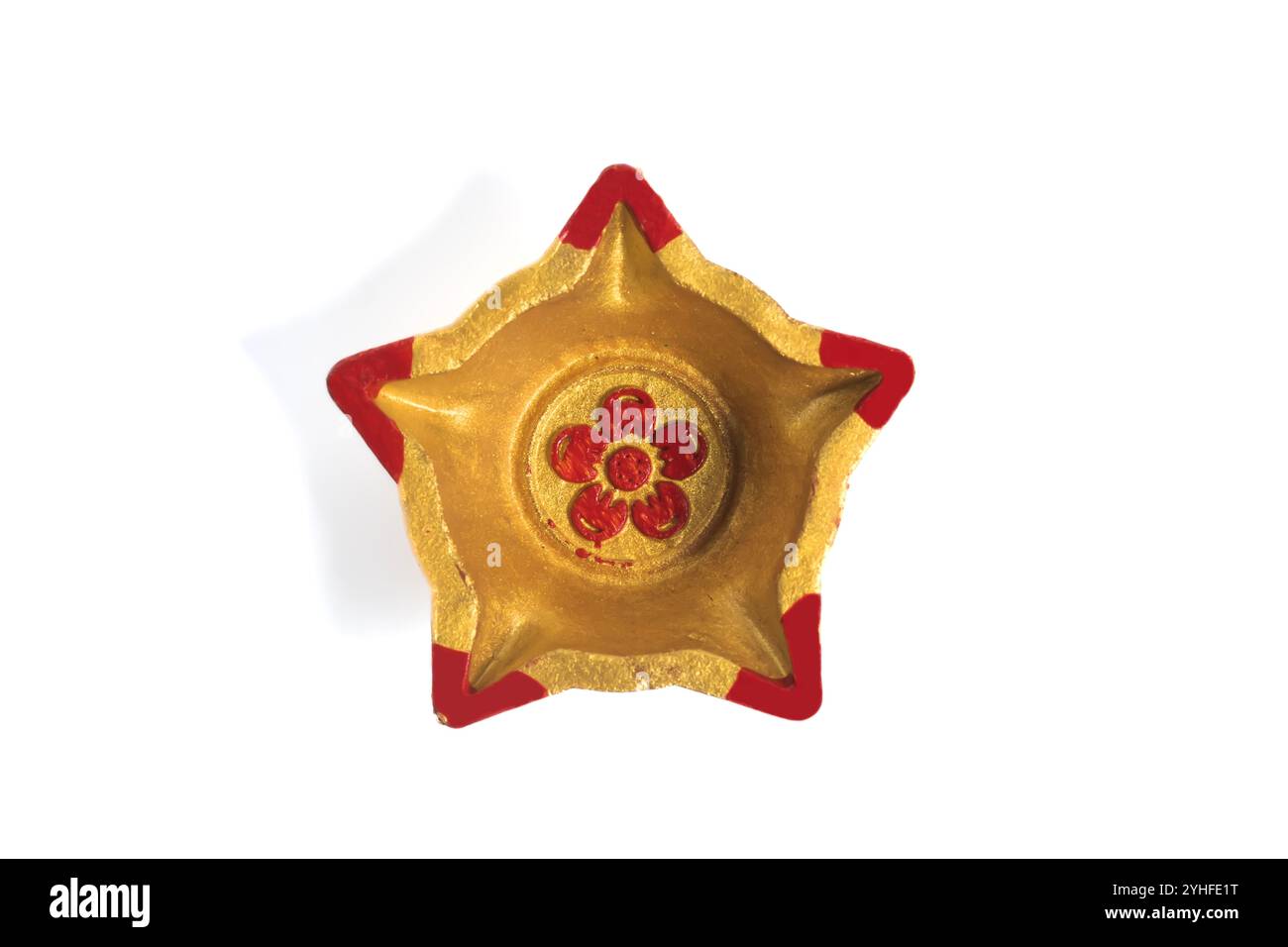 Top view of decorative golden star shape diya on white background ...
