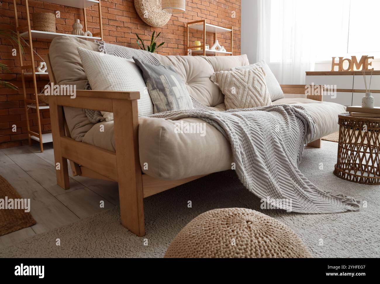 Soft couch with cushions and plaid in living room interior Stock Photo ...