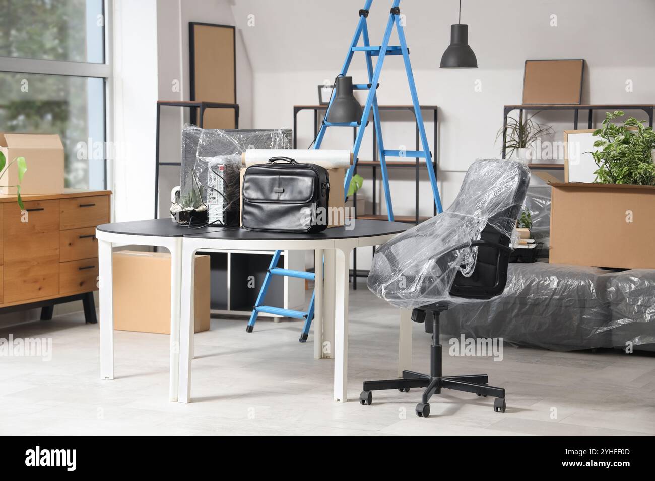 Interior of office with desk, boxes and stepladder on moving day Stock ...