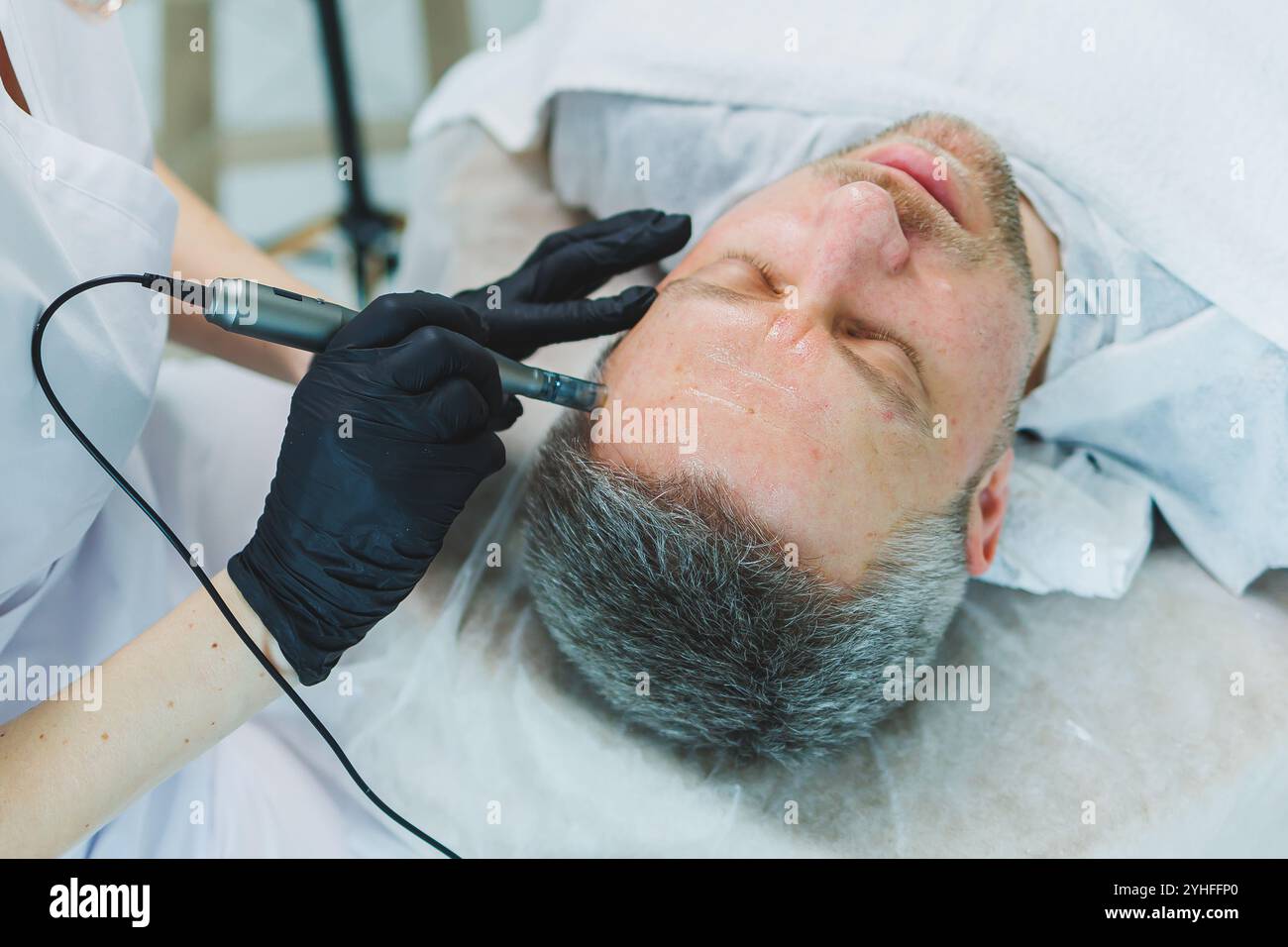 Male cosmetology in a beauty salon. A man takes care of his facial skin ...