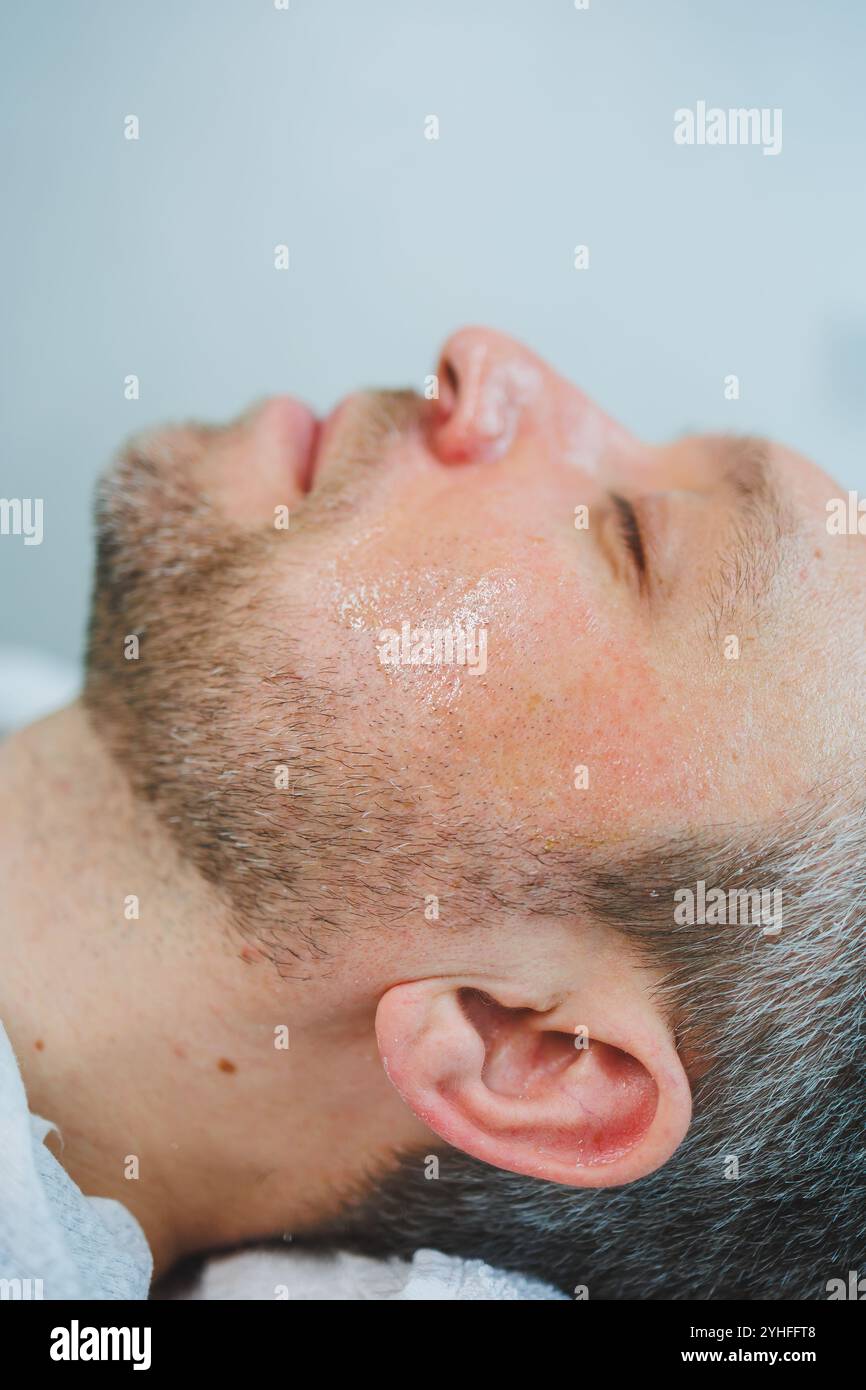 Male cosmetology in a beauty salon. A man takes care of his facial skin ...
