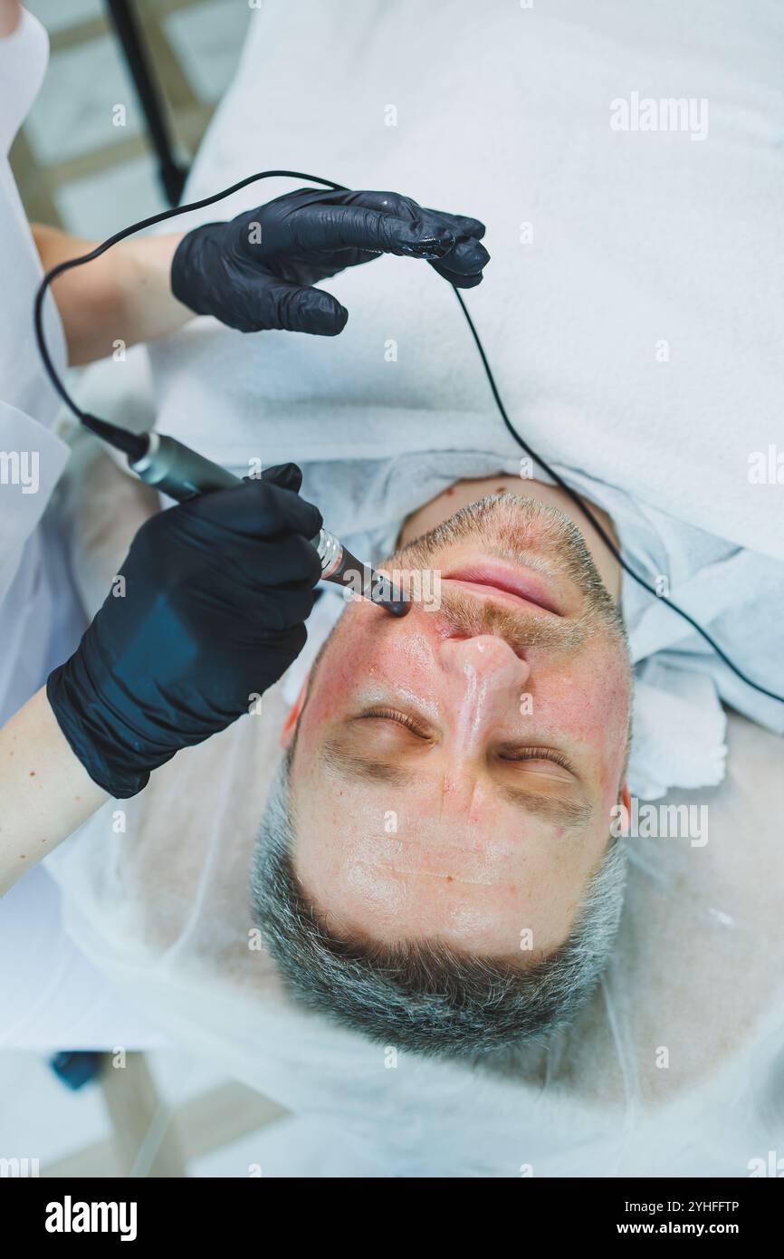 Male cosmetology in a beauty salon. A man takes care of his facial skin ...
