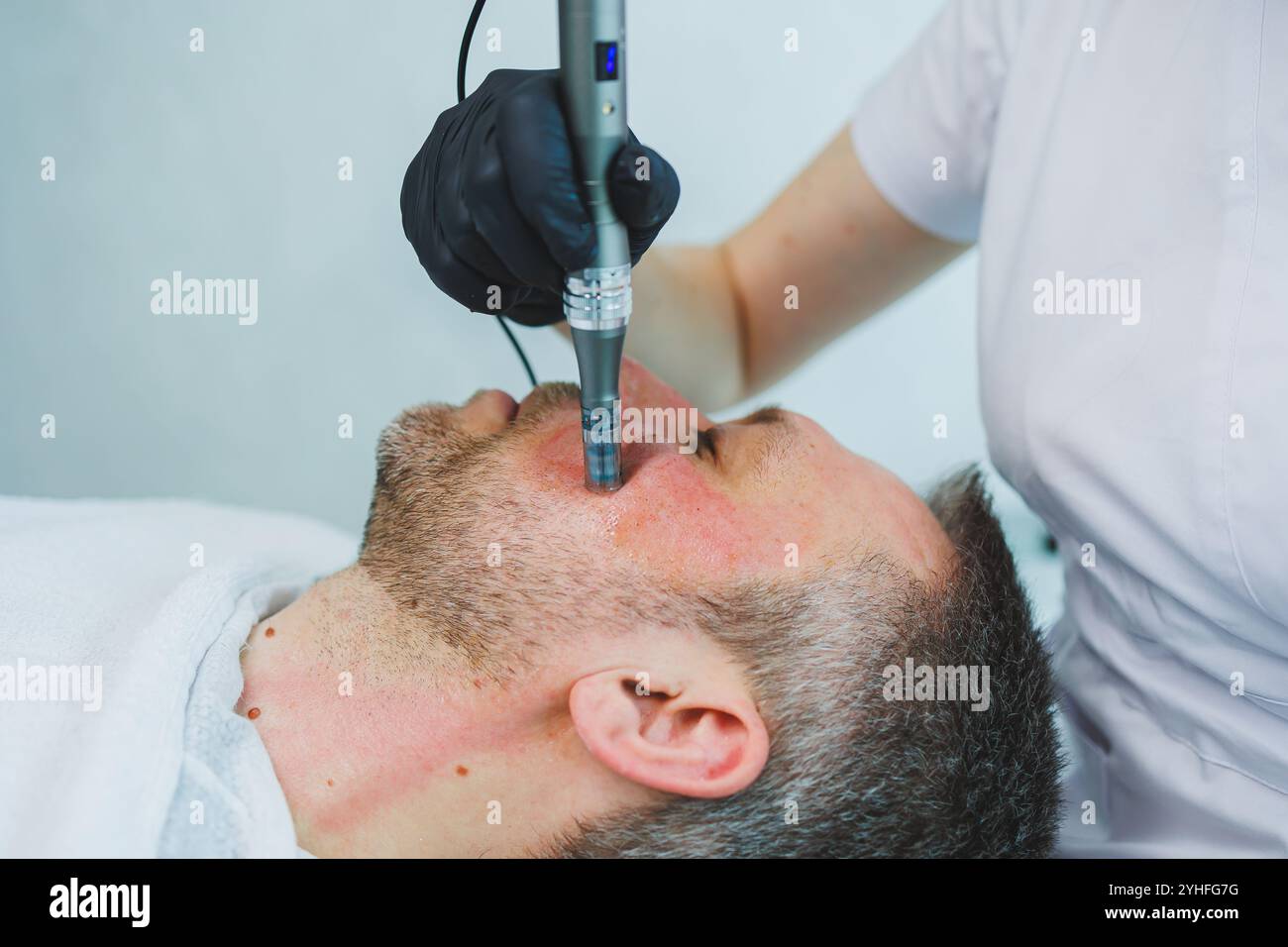 Male cosmetology. A man lies at a cosmetologist for a facial treatment ...