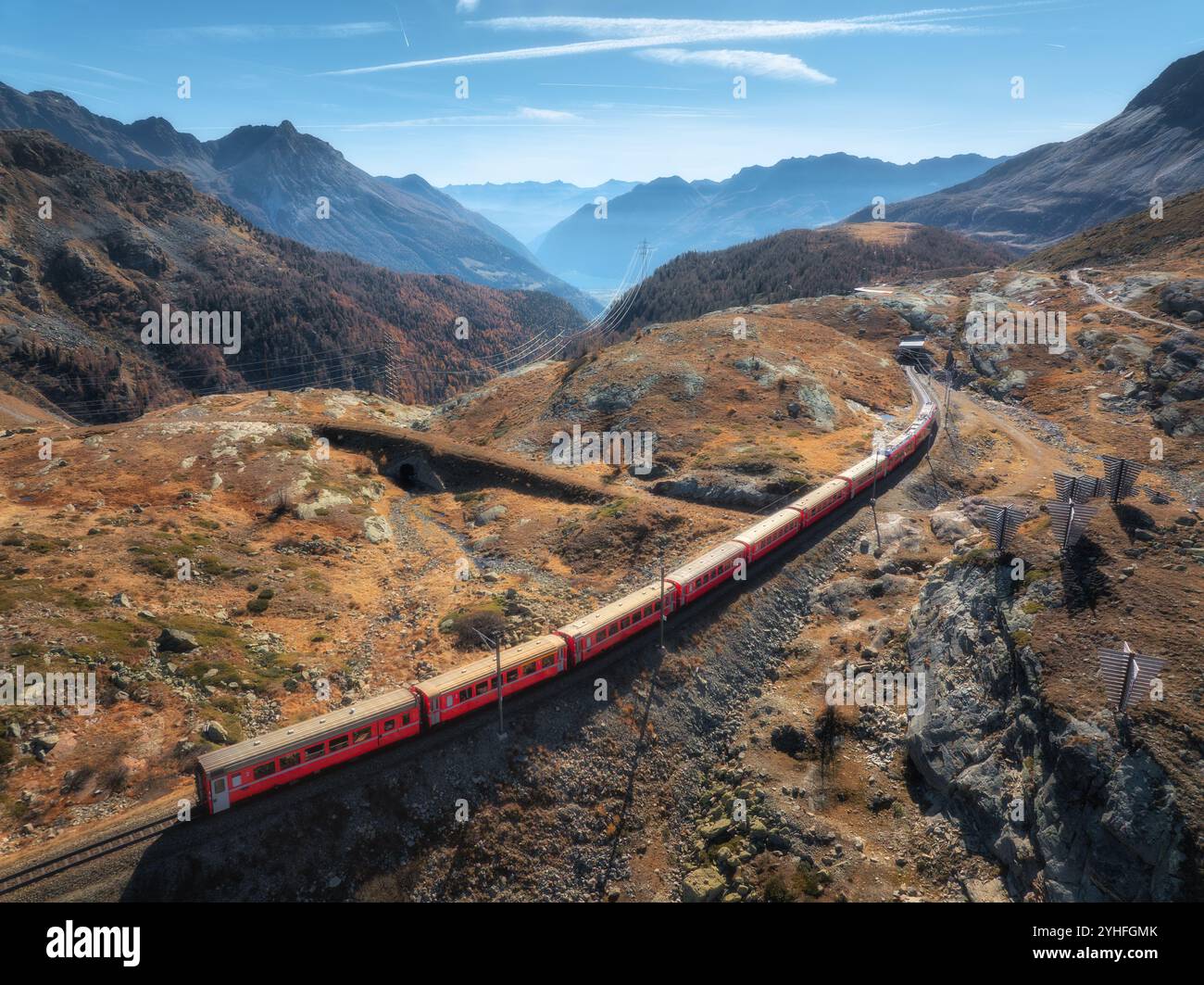 Aerial view of red train is moving in the swiss alps valley Stock Photo ...