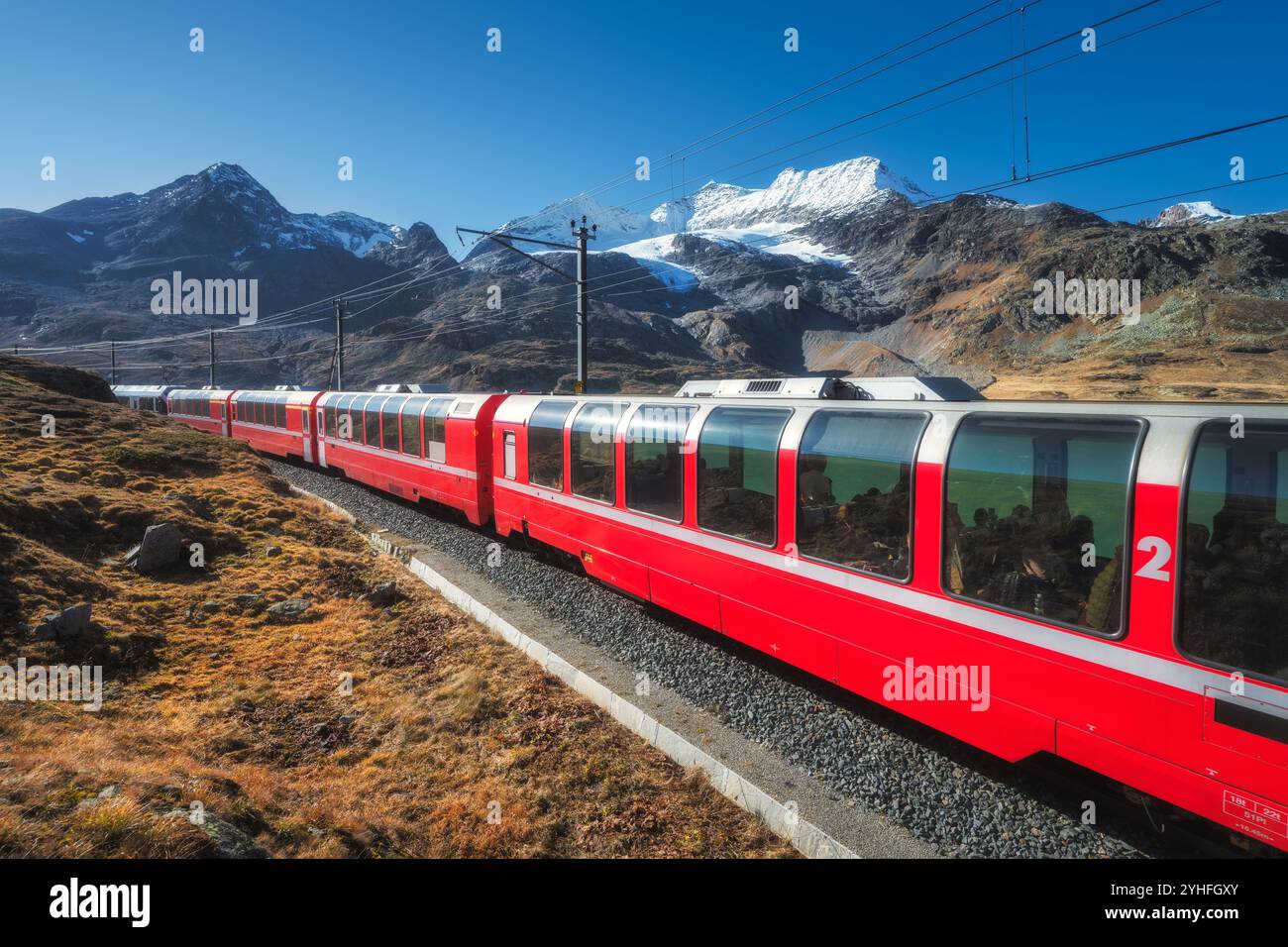 Red train is moving along railway in swiss alps mountain. Autumn Stock ...