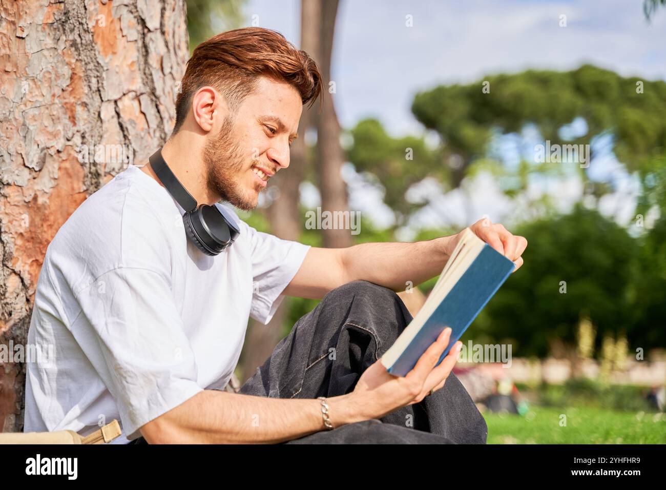 Man reading book under tree hi-res stock photography and images - Alamy