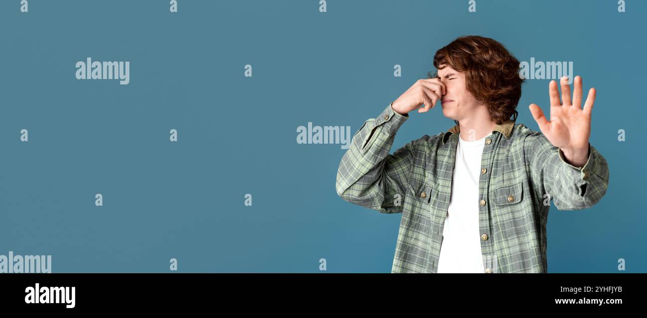 Bad smell concept. Young guy closing his nose and expressing disgust on ...