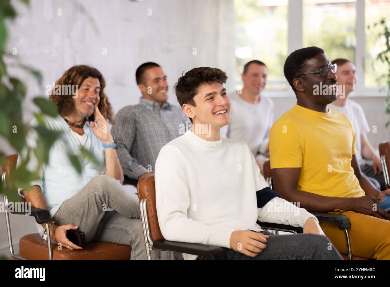 Group of men listening to lecture in auditorium cheerfully Stock Photo ...