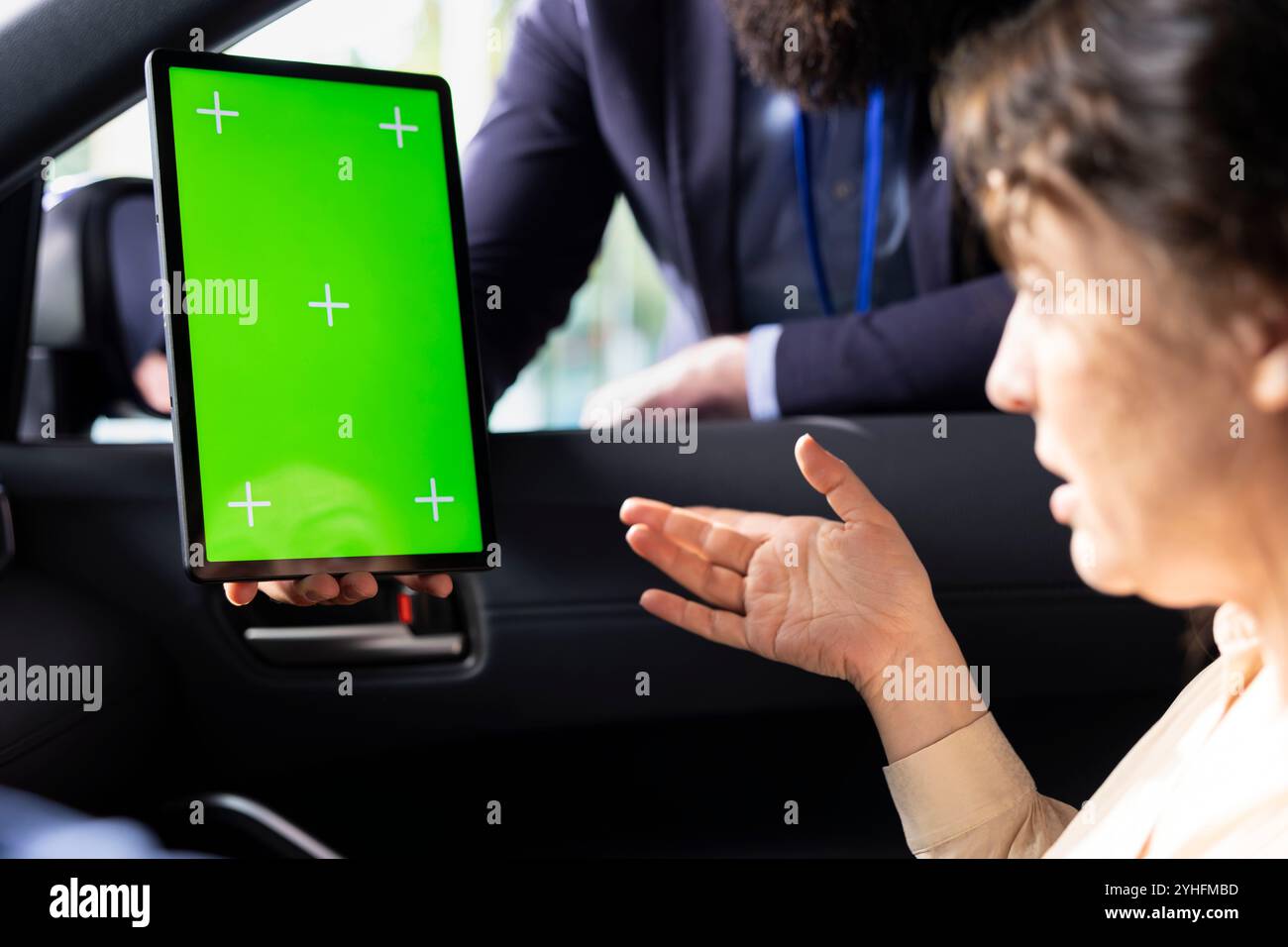 Car dealership worker holding chroma key device, asking driver ...