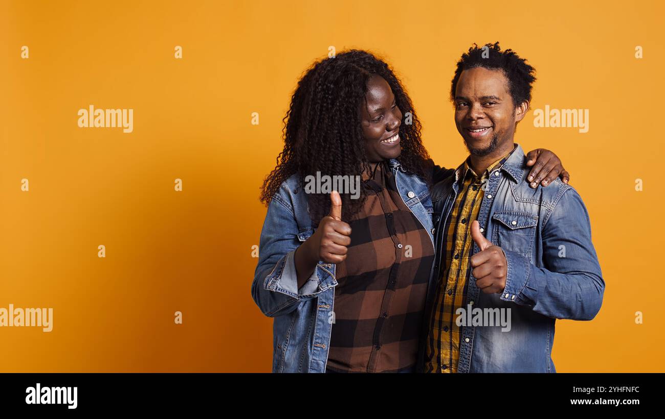 Affectionate husband and wife giving a like symbol on camera, african ...