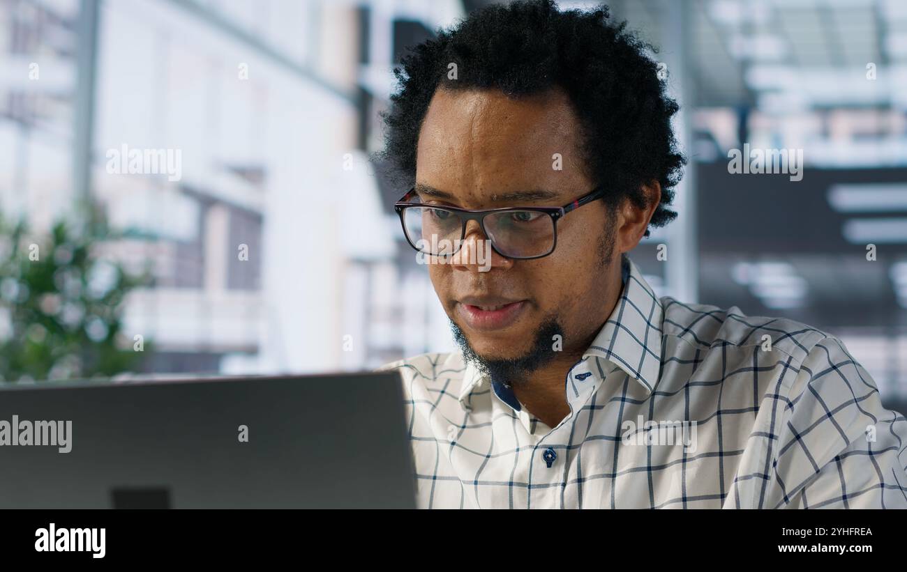 Black man employee joins a telecommuting session at his office desk ...