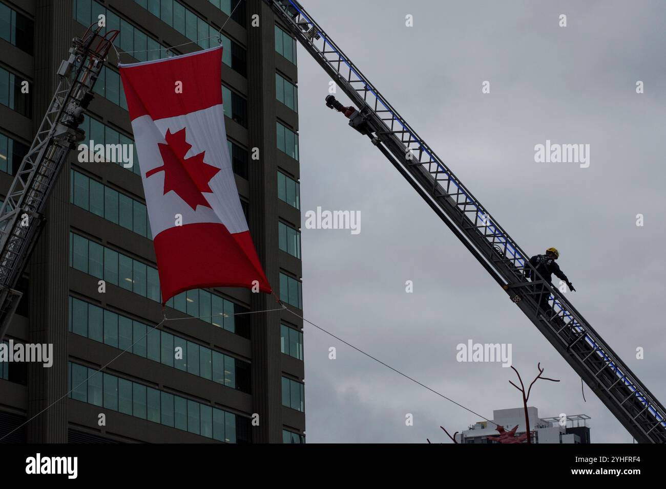 A Canadian Flag hung from a fire truck ladder Stock Photo - Alamy