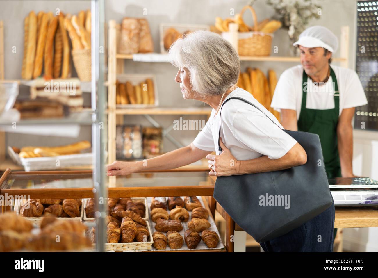 Elderly woman choosing pastries in bakery Stock Photo - Alamy