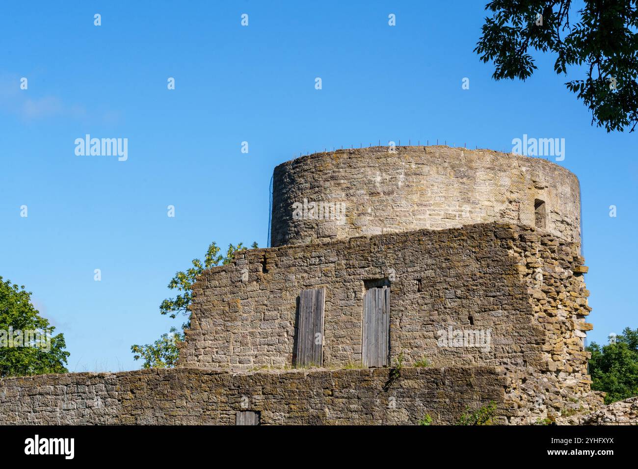 Ancient stone tower ruins standing against a clear blue sky ...