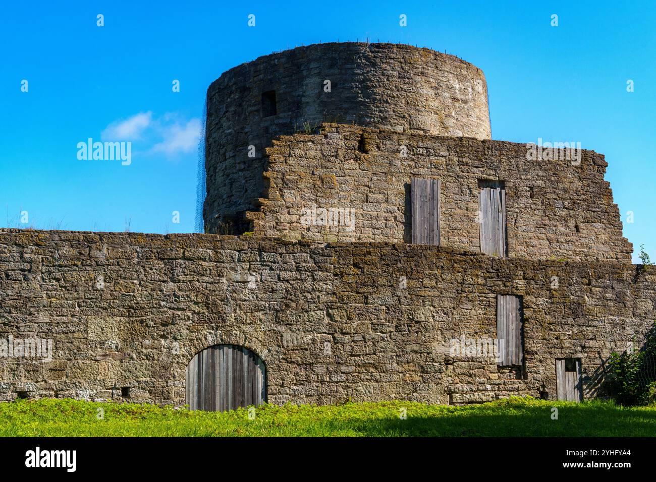 Ancient stone tower ruins standing against a clear blue sky ...