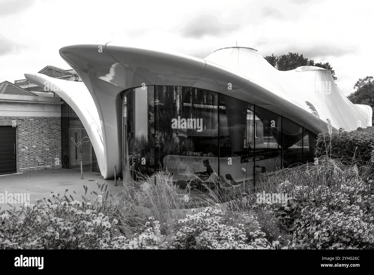 A modern, organic-shaped building with curved glass walls and white ...