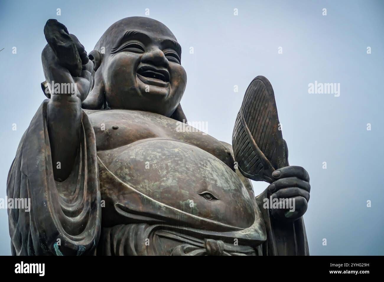 A close-up of the Laughing Buddha statue at Bai Dinh Temple, holding a ...