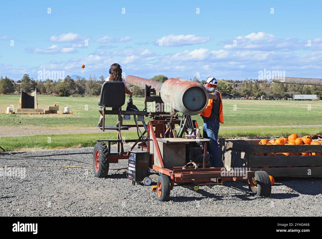 A young child firing off an air-powered pumpkin cannon at a target at a ...