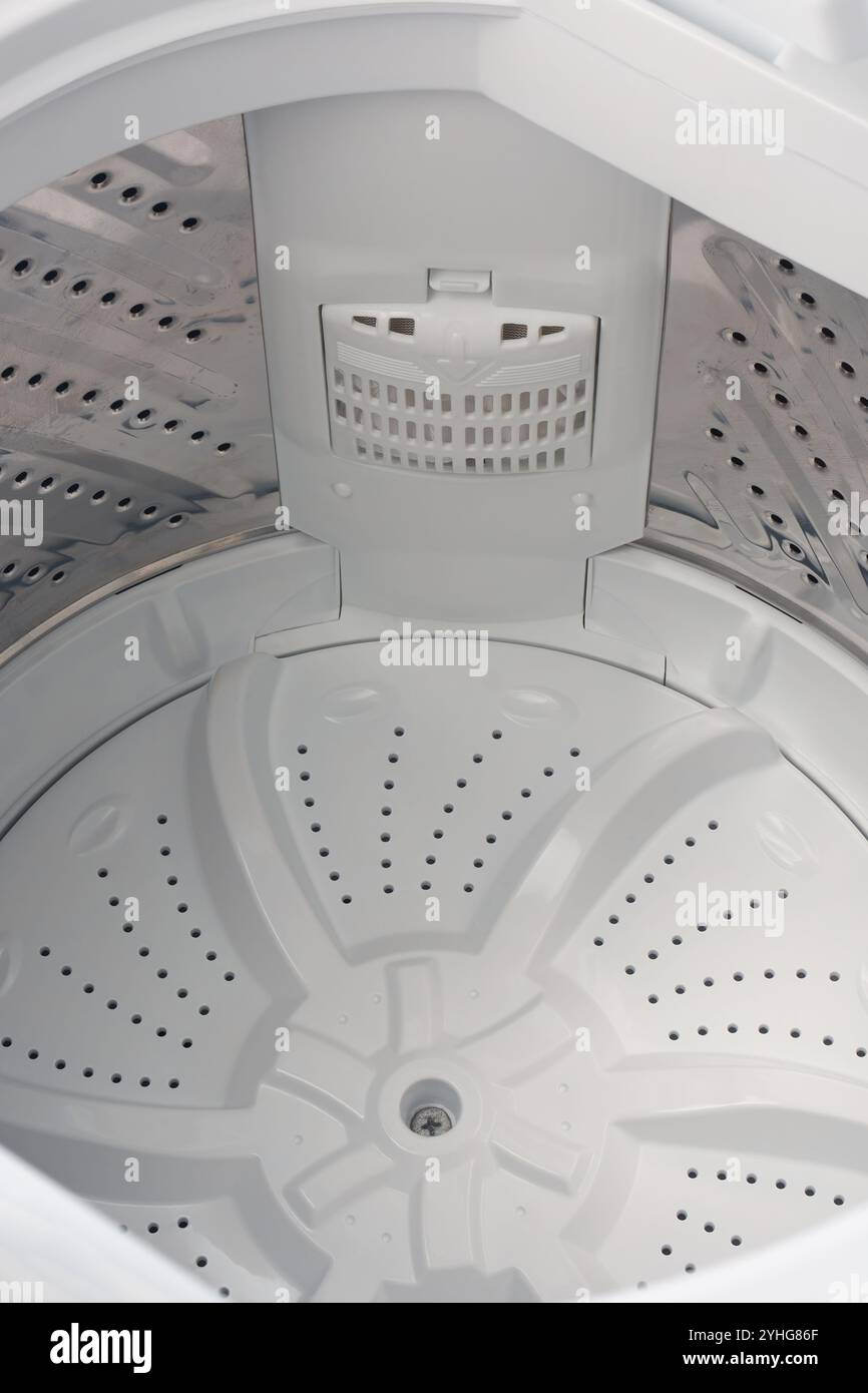 inside view of top loading washing machine white steel drum in close-up ...