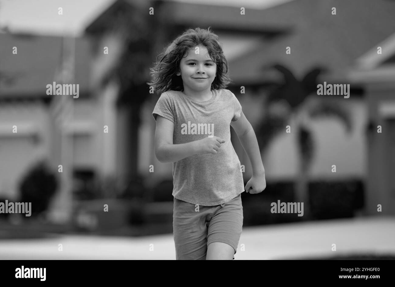 Cute kid boy running across american neighborhood street. Summer ...