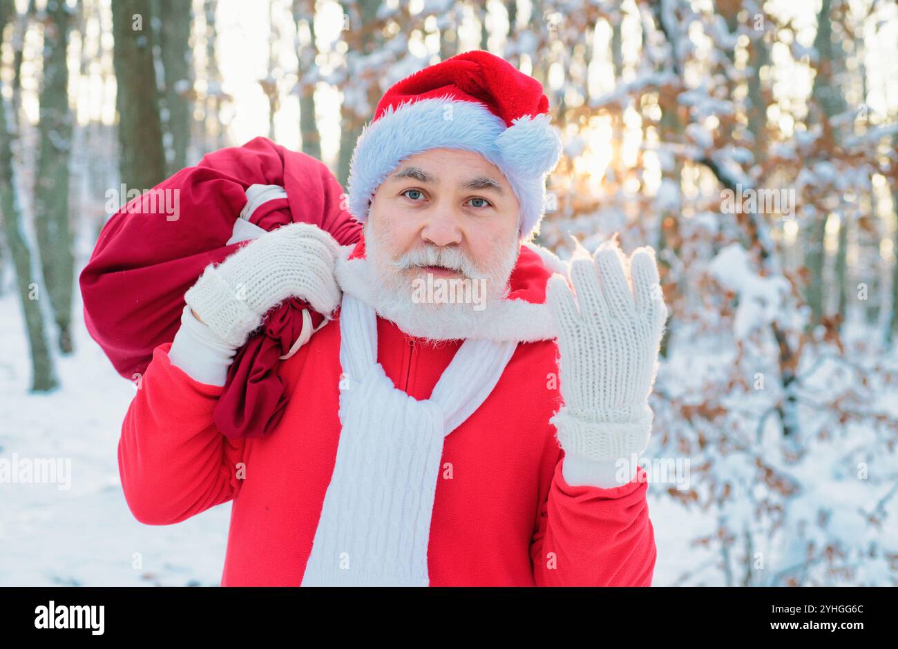 Santa in the winter field. Santa Claus on Christmas Eve is carrying ...
