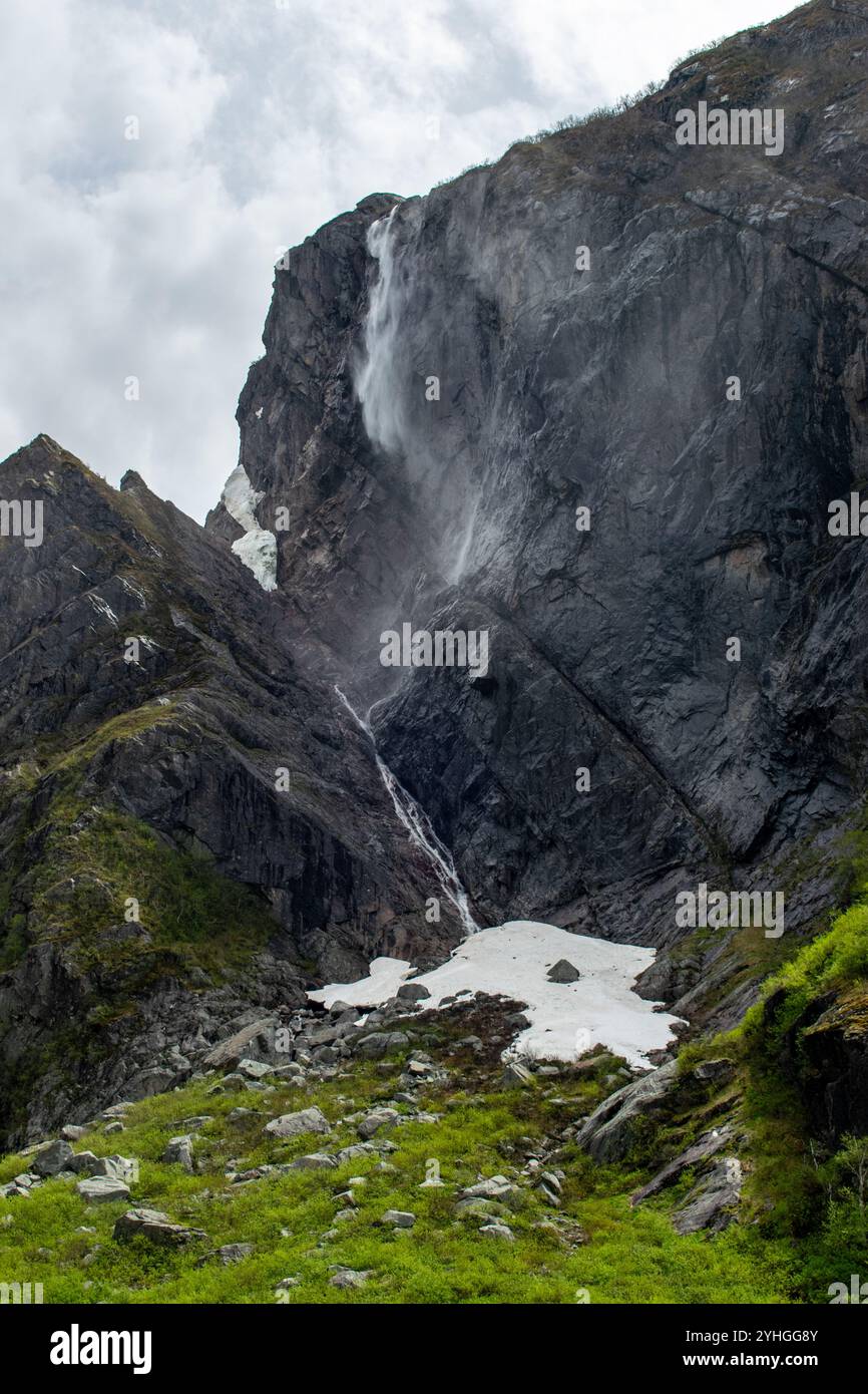 A small waterfall flows gently over the edge of a cliff in Gros Morne ...