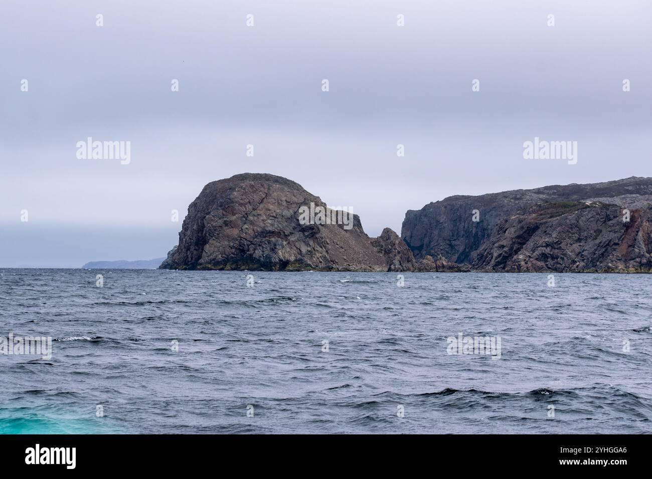 A towering rock stands proudly in the ocean, its imposing presence a ...
