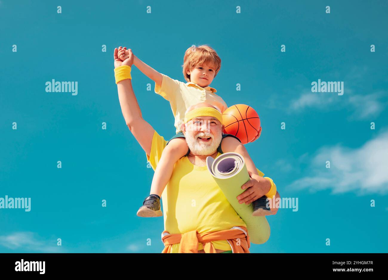 Sport yoga and fitness. Grandfather giving grandson ride on back in ...