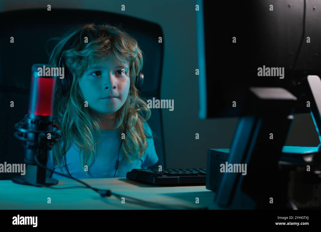 Child learning online at night, using desktop computer in living room ...