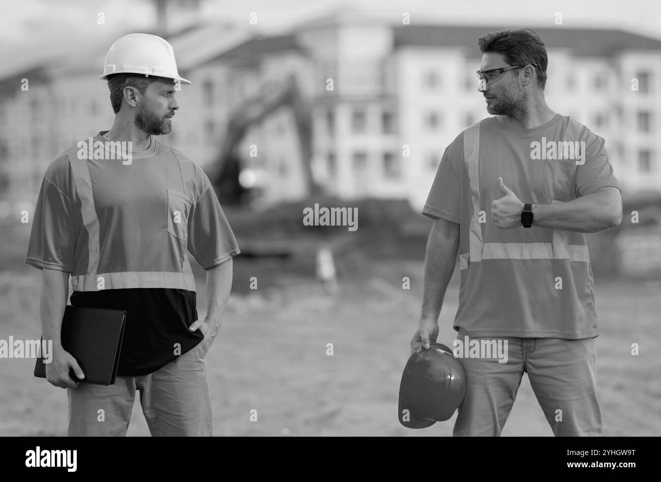 Two builders in a hard hat is busy working on a construction project at ...