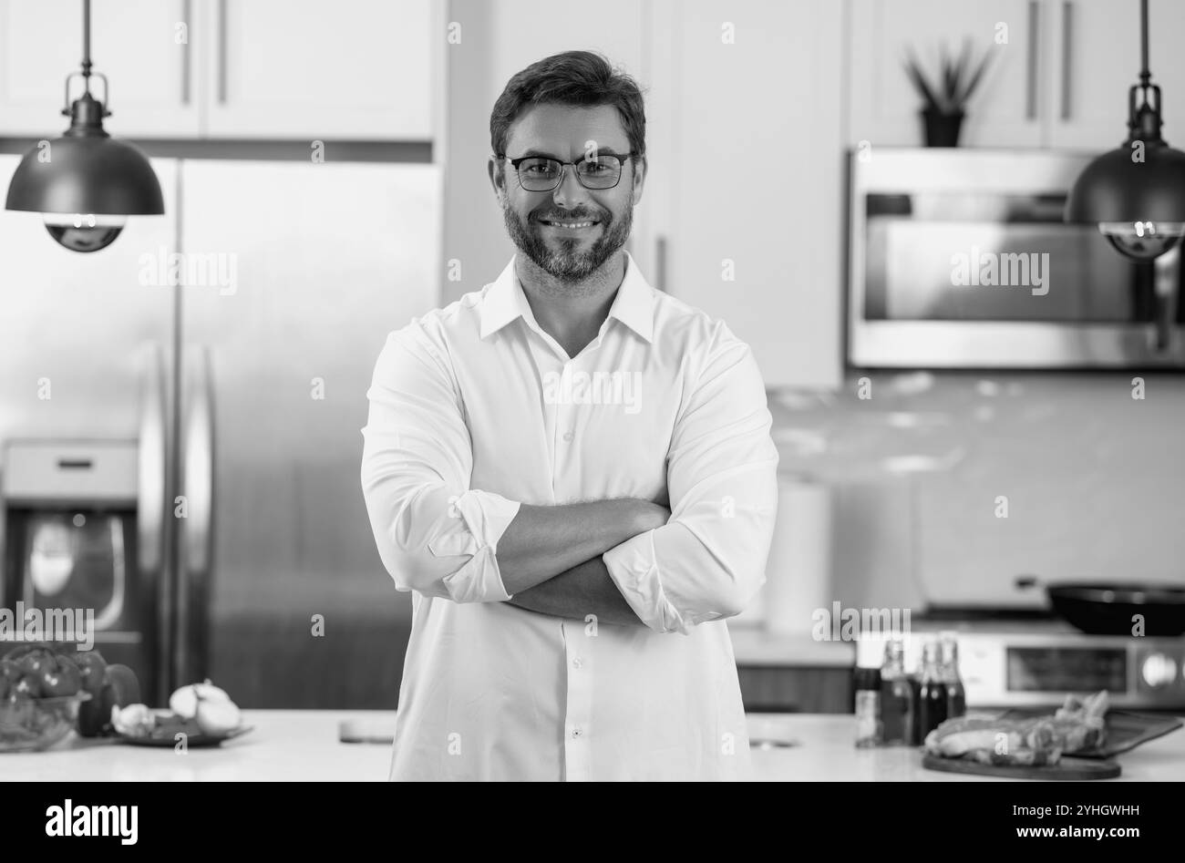 Handsome man cooking in kitchen. Mature man cooking with vegetables and ...