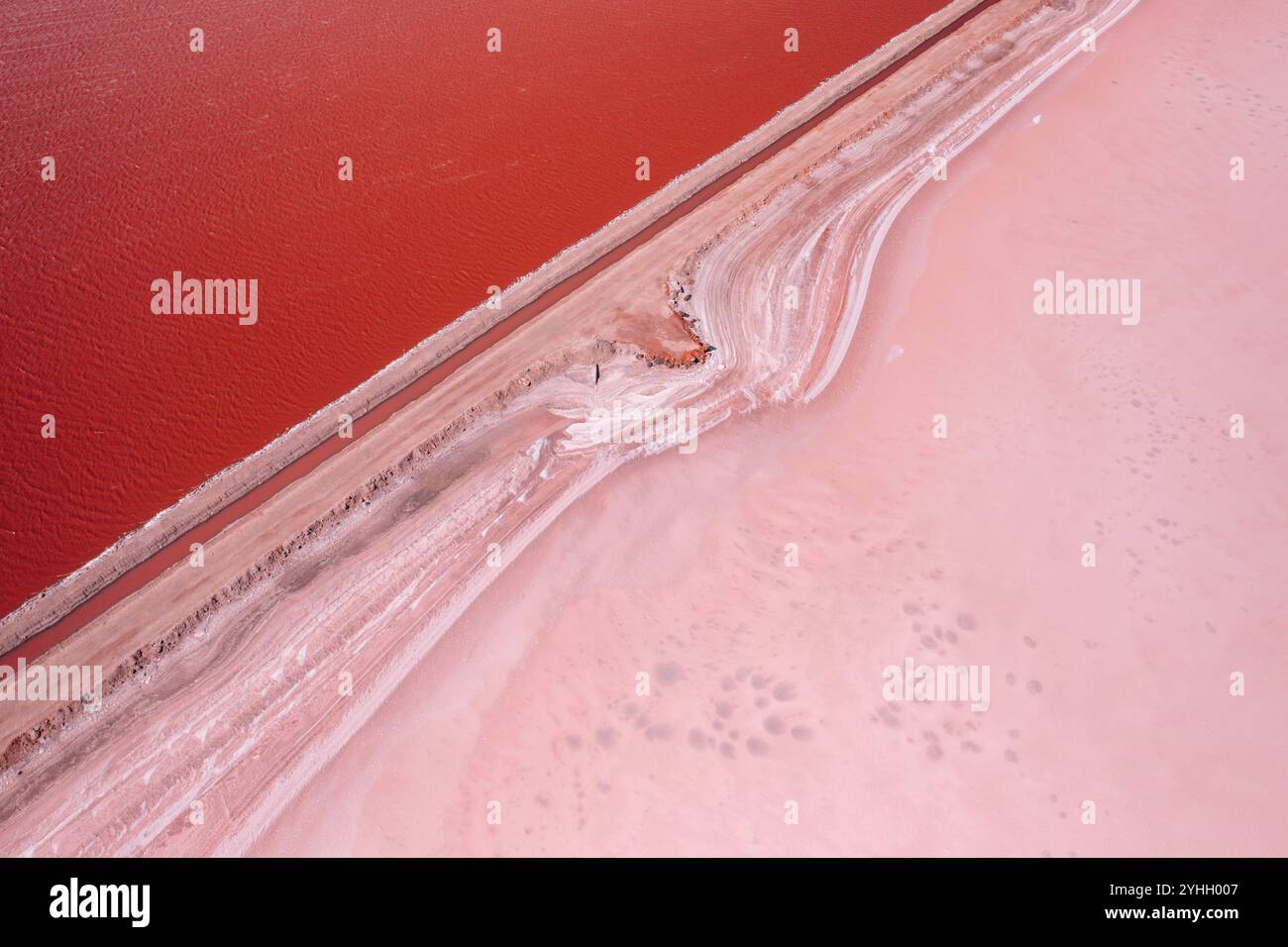 Pink lake with a clear contrast between the salt plain and water. Rocks ...
