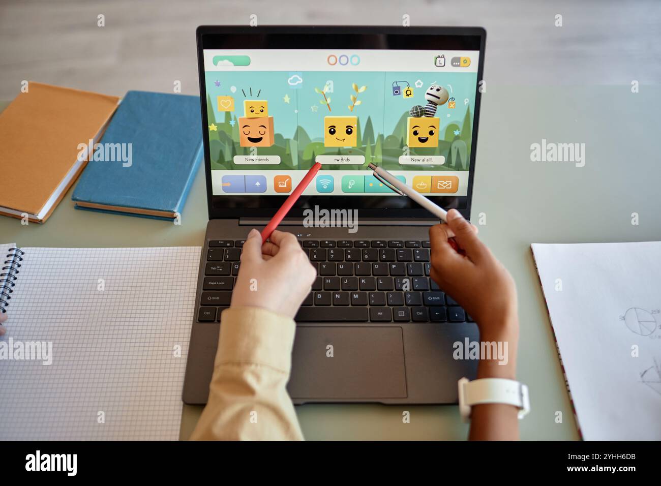 Top view of open laptop with cute characters on screen and two ...