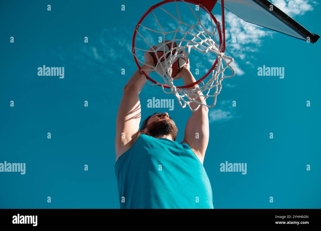 Basketball player making a jump shot against blue sky background Stock ...