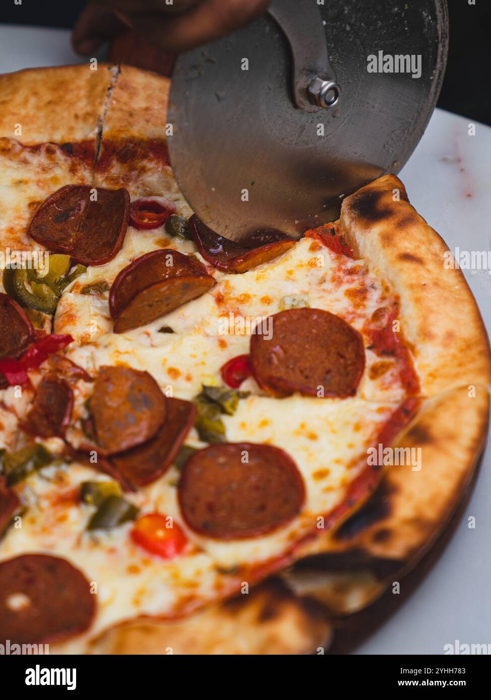 cutting through the pepperoni pizza Stock Photo - Alamy