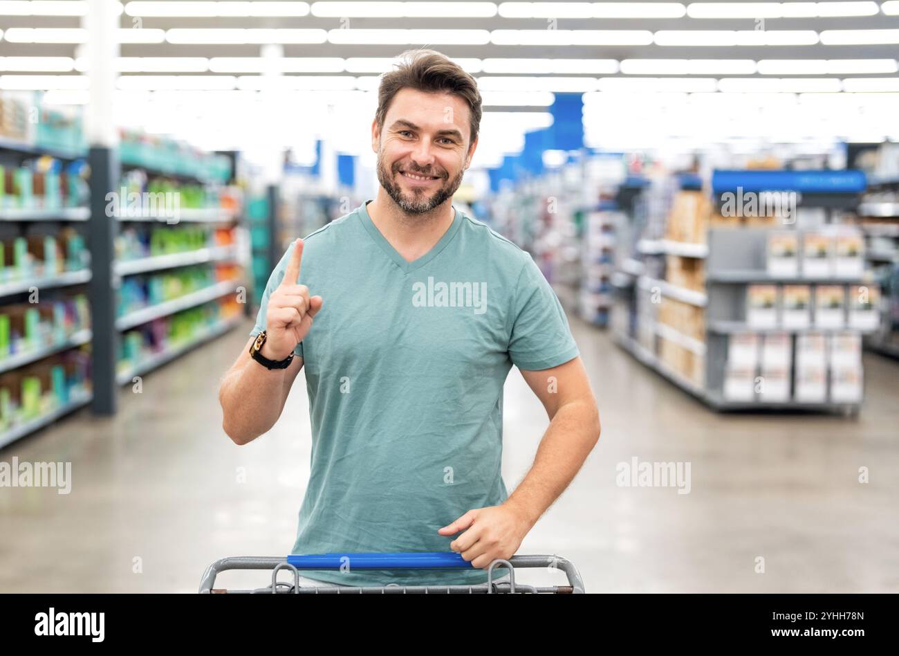 Portrait of man with shopping cart in a store. Supermarket shopping and ...