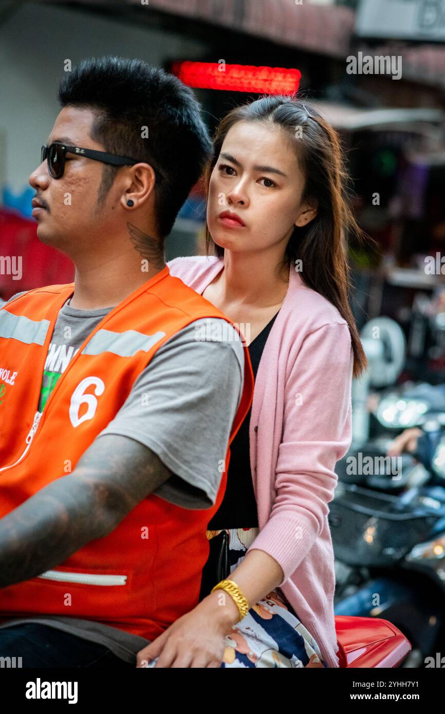 A beautiful young Thai lady rides on the back of a motorbike taxi along Soi Buakhao, Pattaya ...