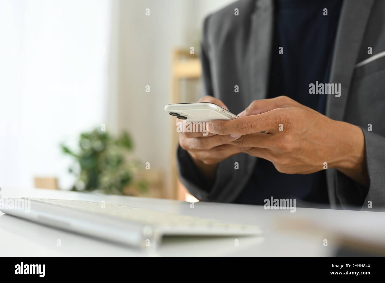 Businessman in formal suit checking smartphone notifications at ...