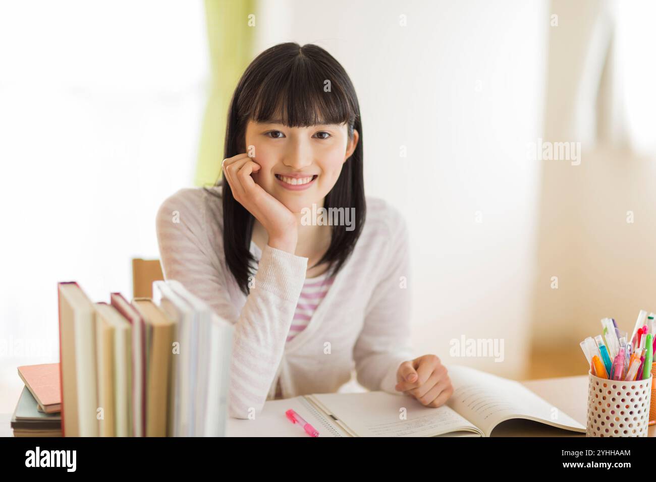 Smiling girl with cheekbones at study desk Stock Photo - Alamy