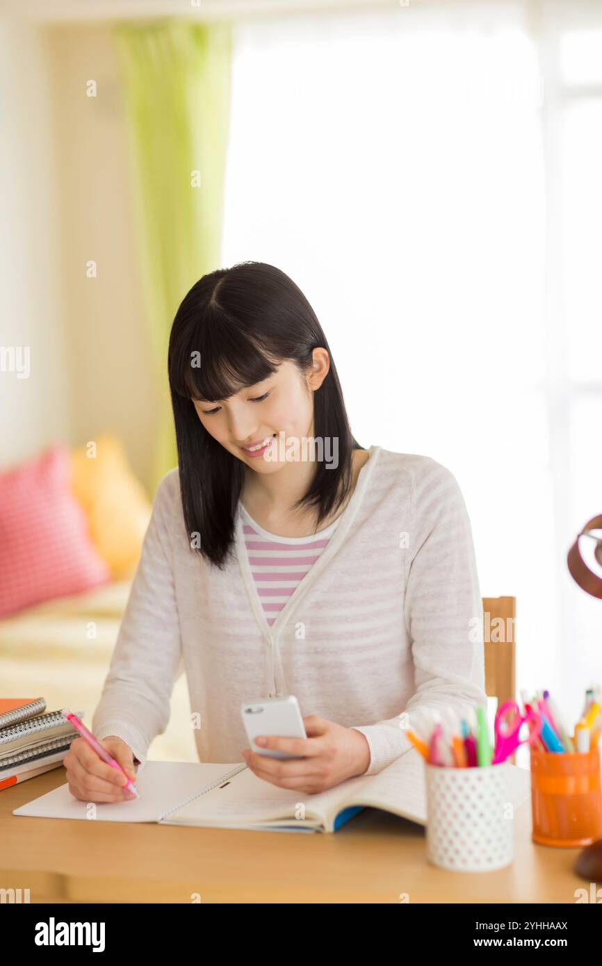 Girl studying using a smartphone Stock Photo - Alamy