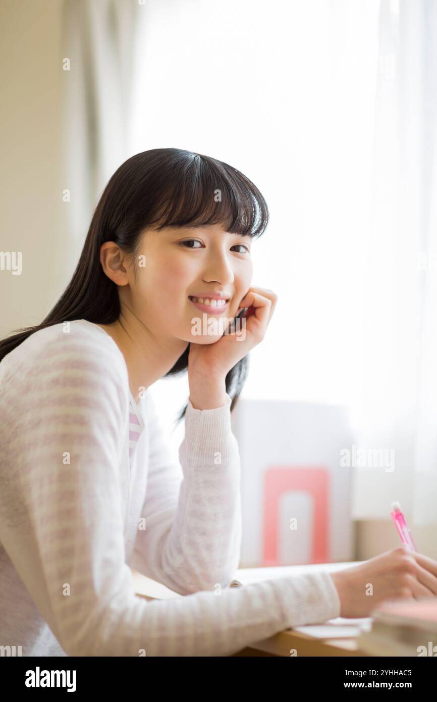 Smiling girl with cheekbones at study desk Stock Photo - Alamy
