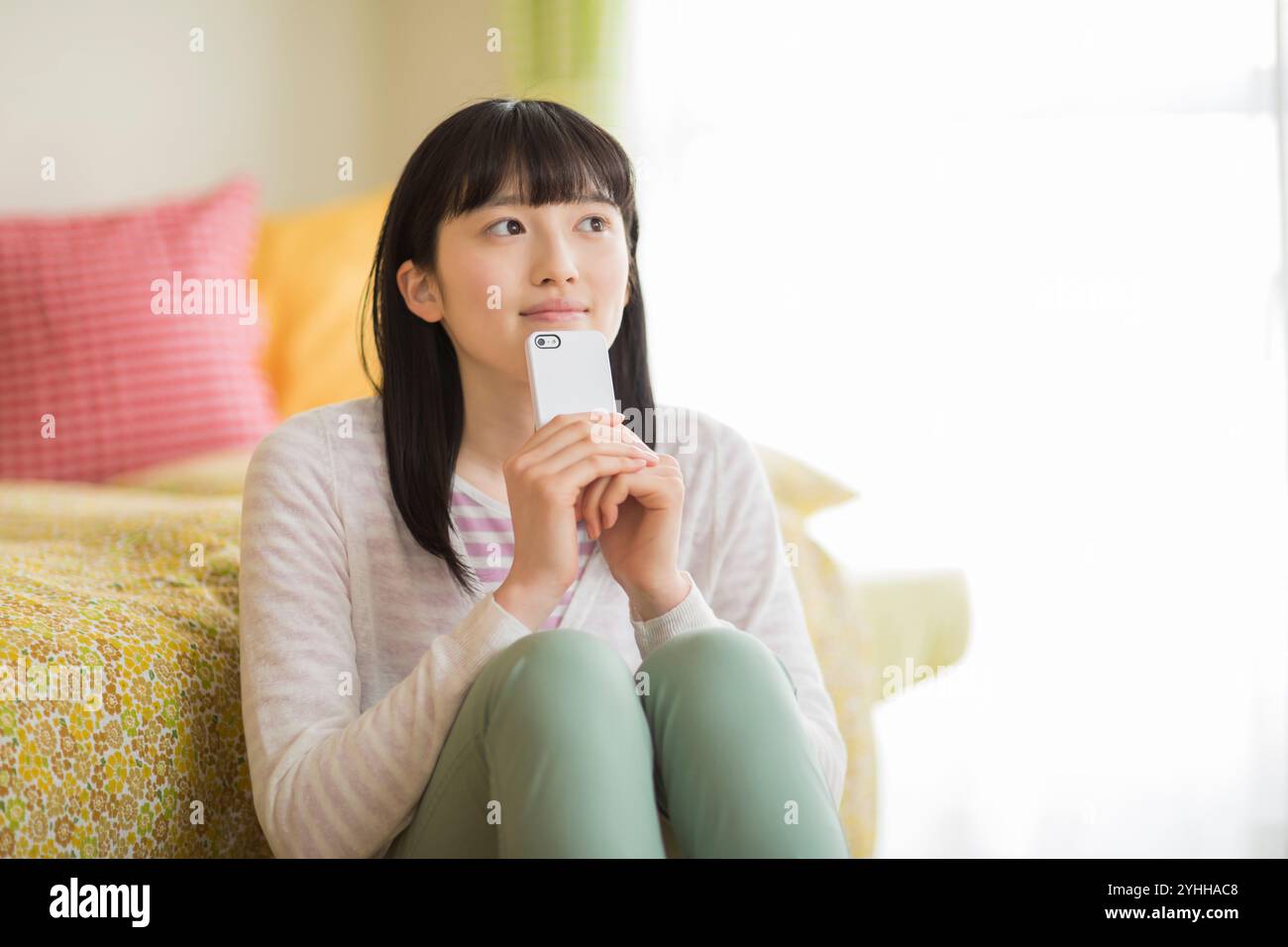 Girl thinking with smartphone Stock Photo - Alamy