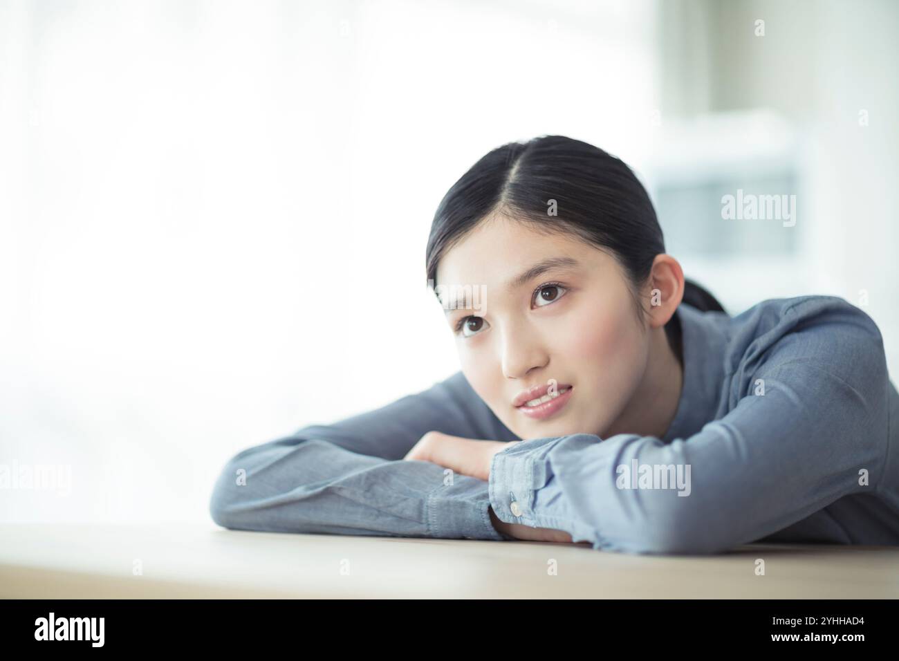 Girl lying on table thinking Stock Photo - Alamy