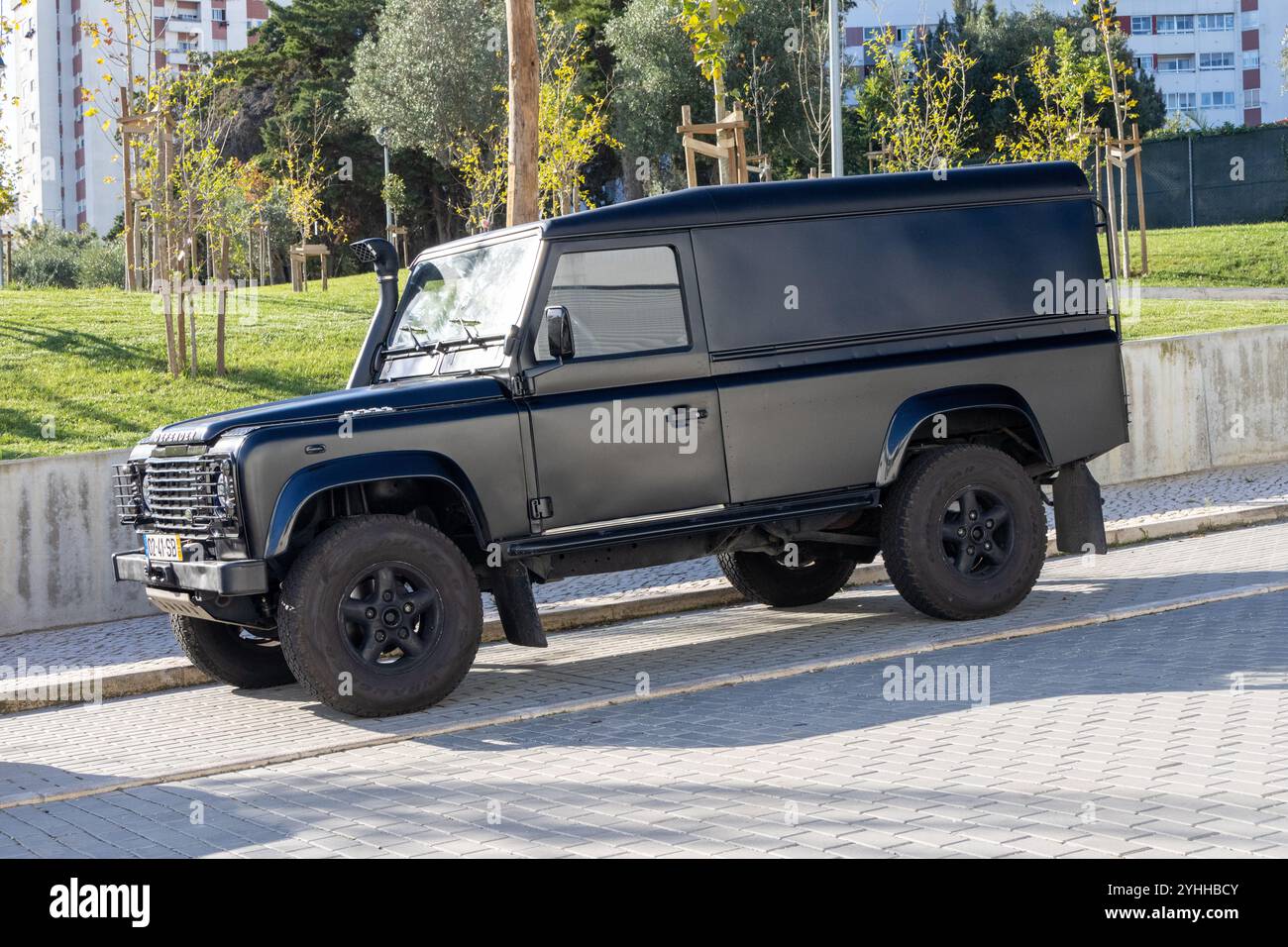 Customized black land rover defender parked near a park in an urban ...