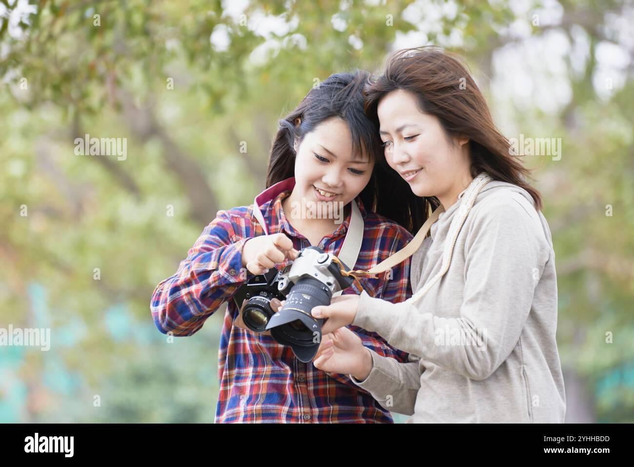 Two women taking a photograph with an SLR camera Stock Photo - Alamy